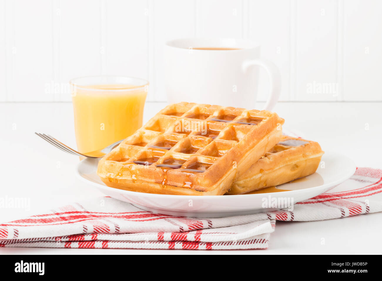 Fresh made waffles and maple syrup served with juice and coffee Stock ...