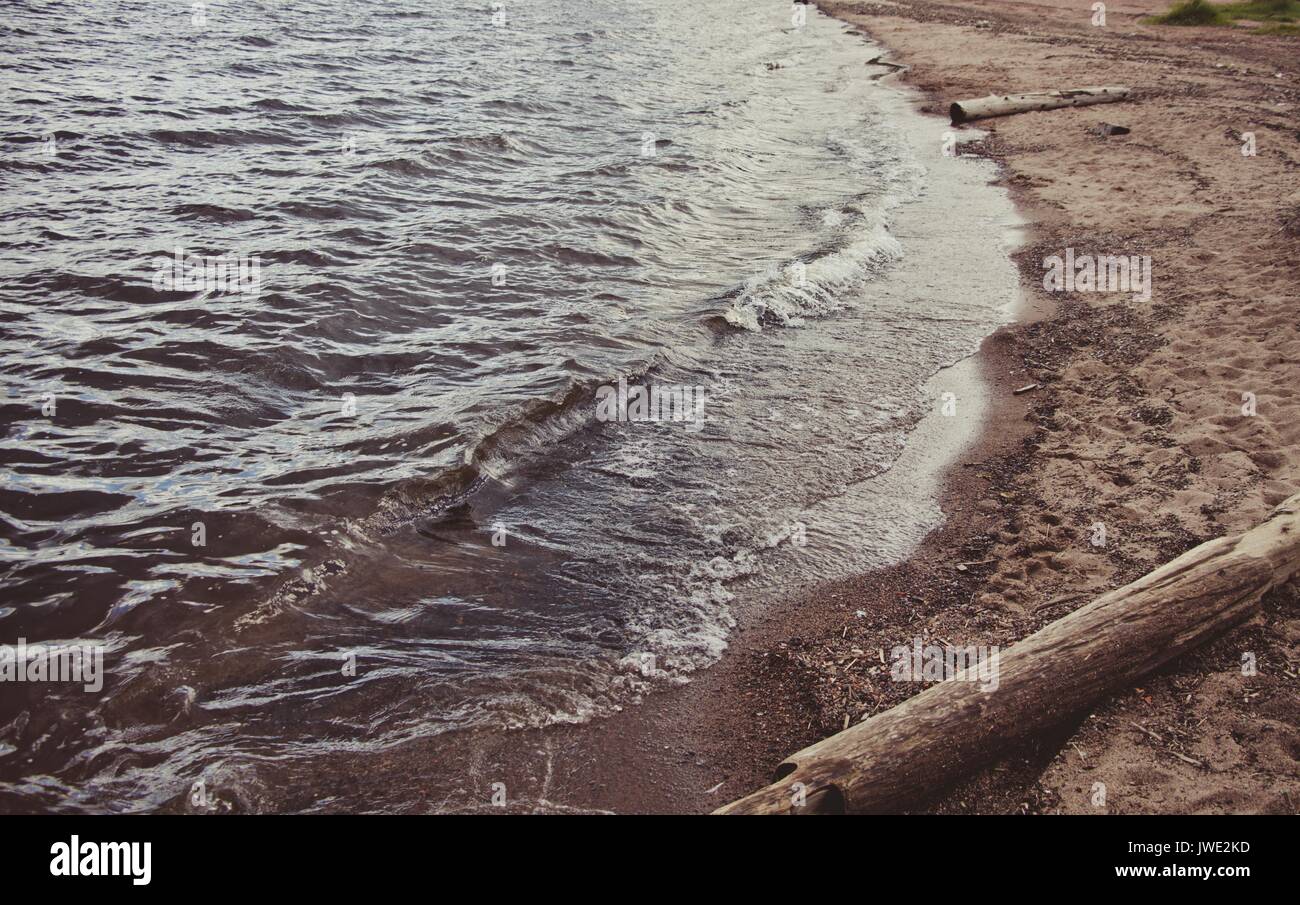 The log on the shore of a huge and clean lake Stock Photo - Alamy