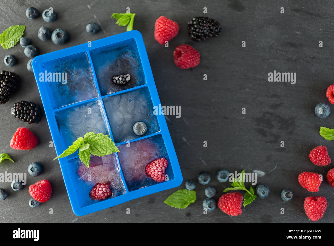 Fruit ice cubes with organic berries Stock Photo - Alamy