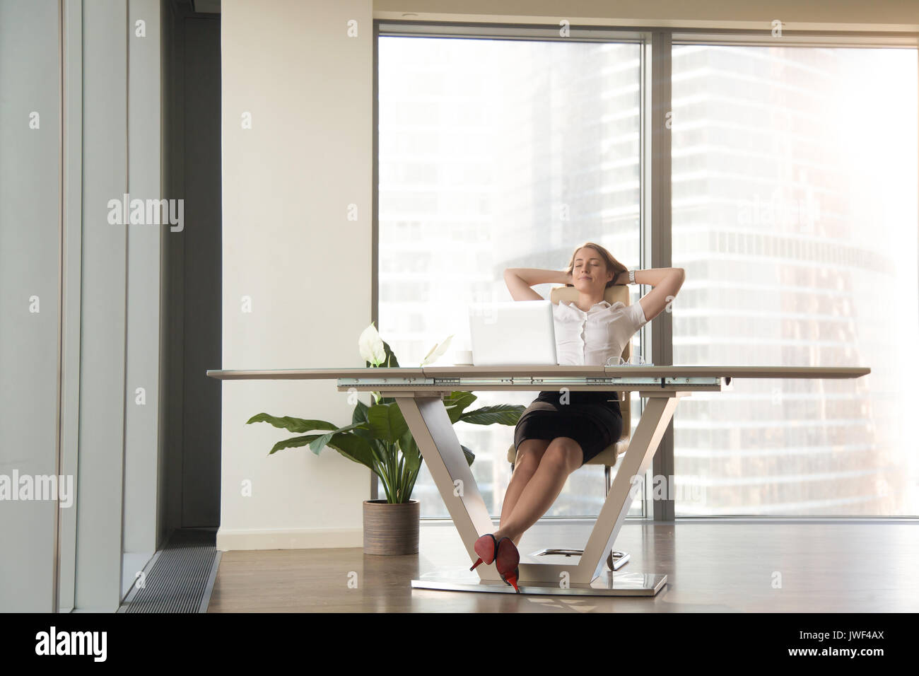 Relaxed businesswoman resting on chair in modern office after wo Stock ...