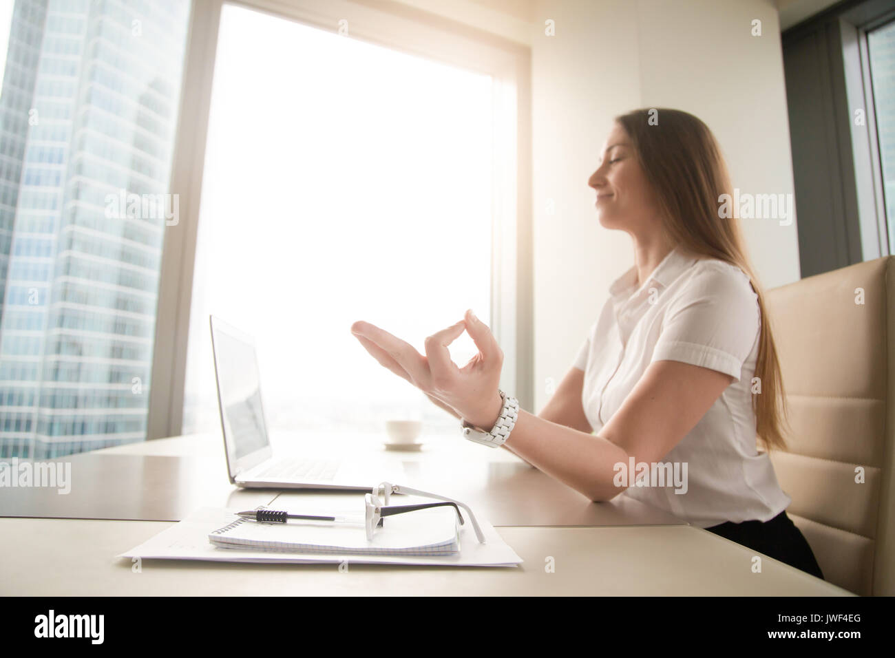 Calm peaceful businesswoman practicing yoga at work, meditating Stock ...