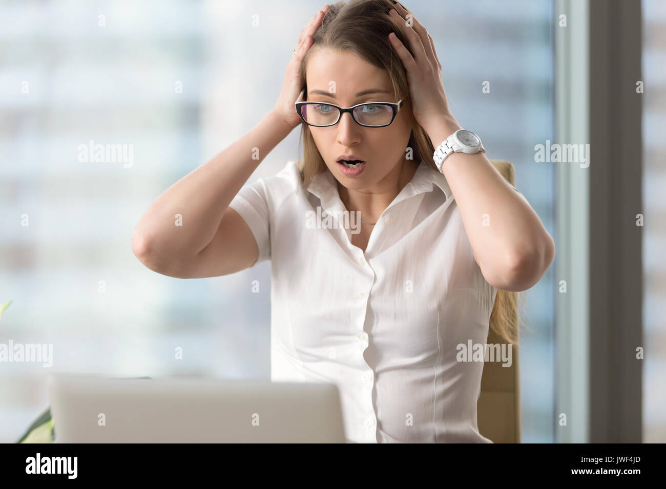 Surprised shocked businesswoman looking at laptop, head in hands Stock ...