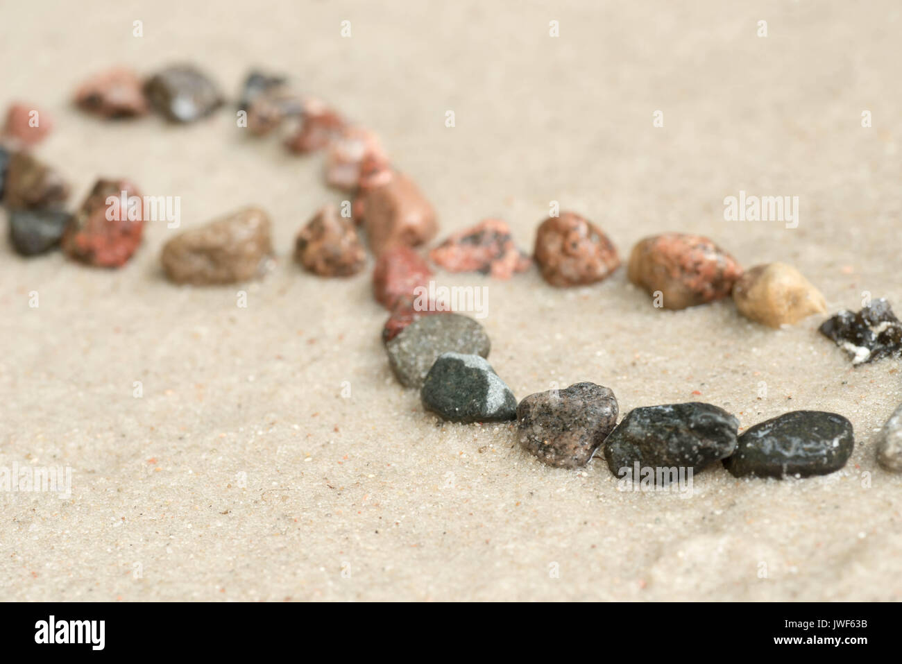 pebble infinity symbol on sand background selective focus Stock Photo ...