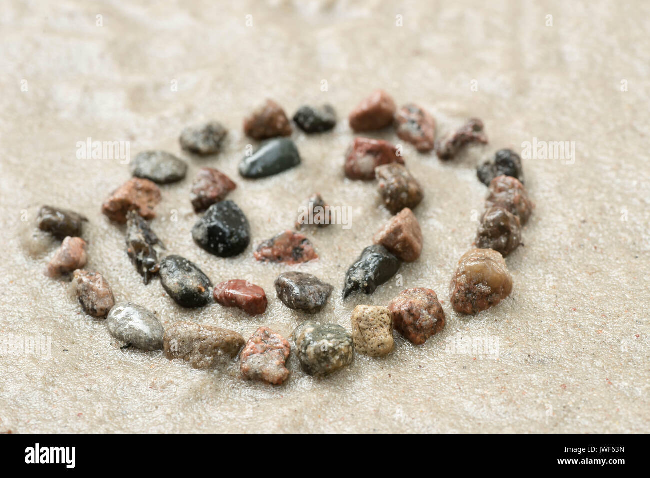 pebble helix symbol on sand background selective focus Stock Photo - Alamy
