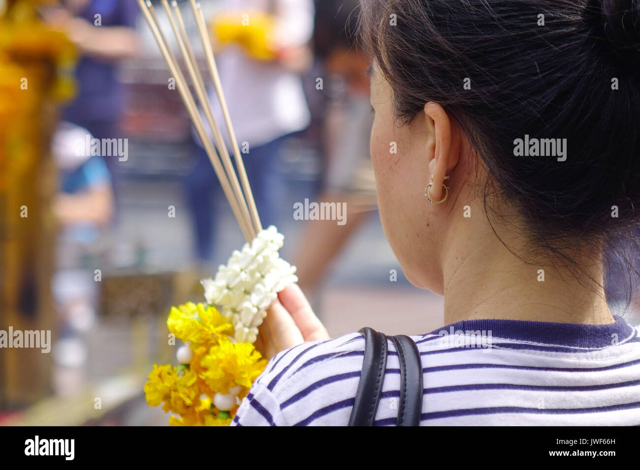 A young woman praying at Erawan Temple in Bangkok, Thailand. Erawan ...