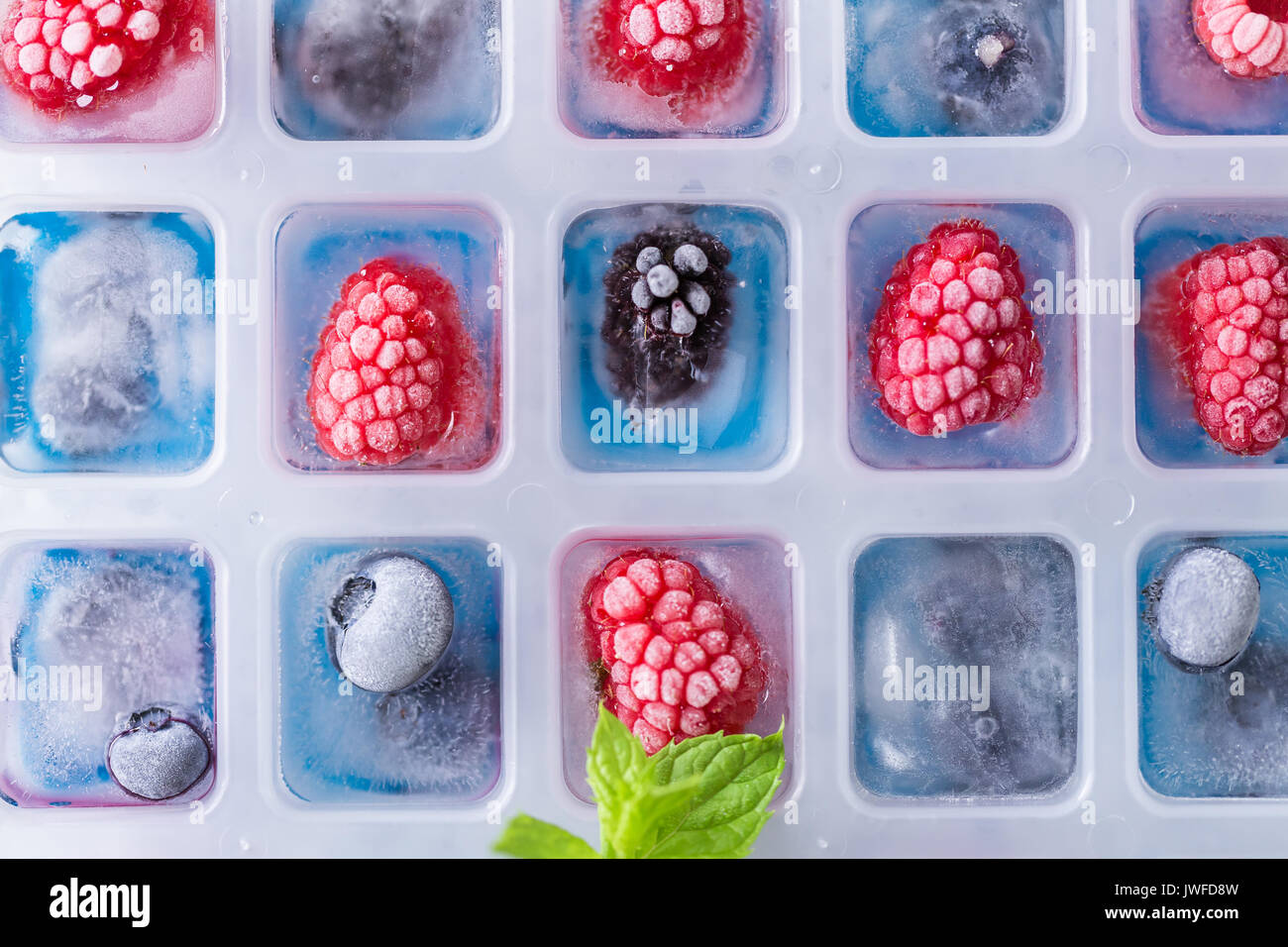 Fruit ice cubes with organic berries Stock Photo - Alamy