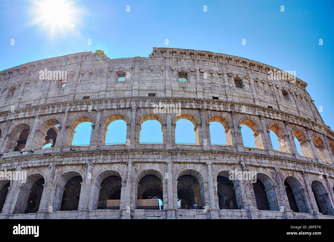 Roman Coliseum on blue sky and sun Stock Photo - Alamy
