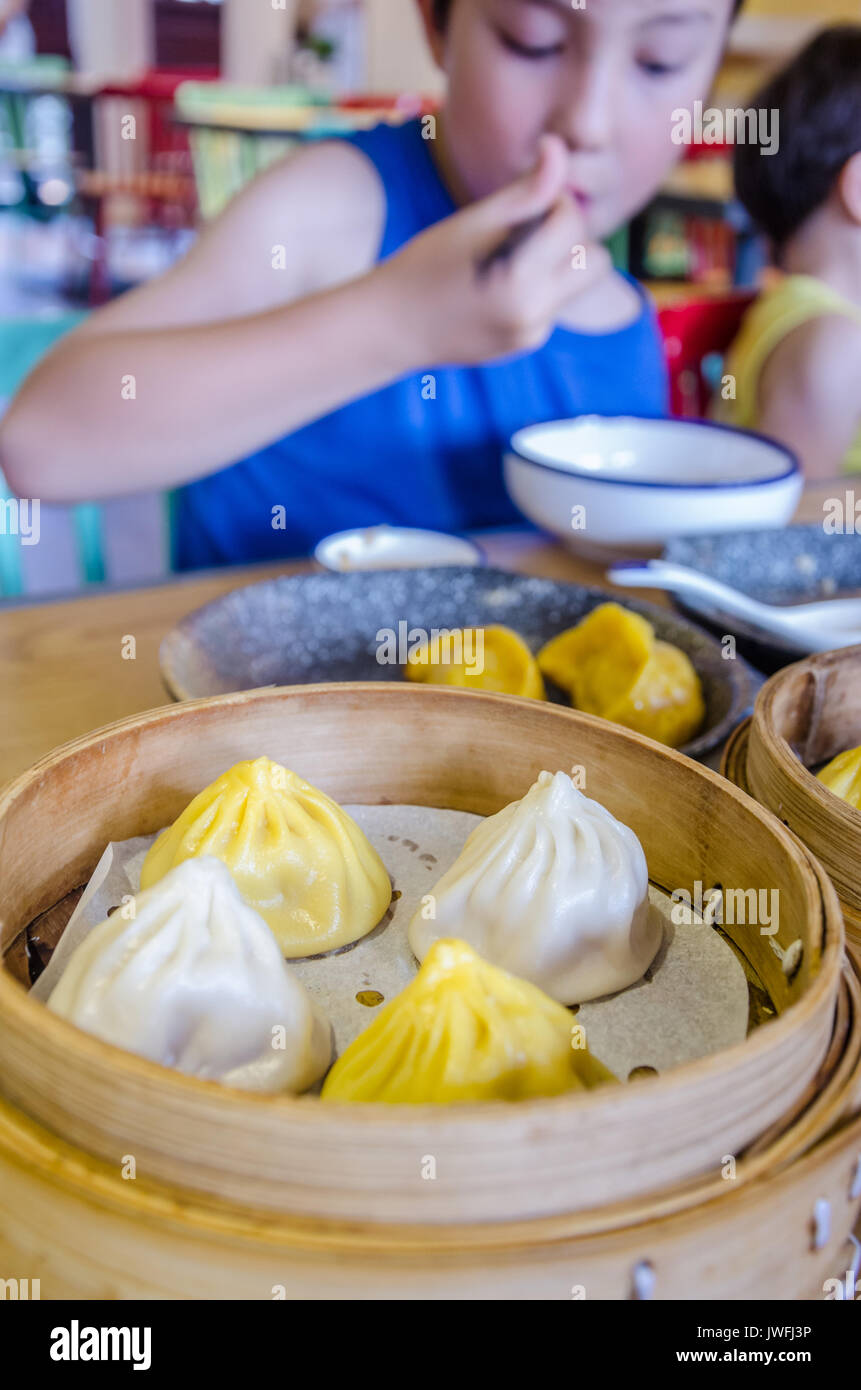 A young boy eats Chinese soup dumplings in Shanghai Stock Photo - Alamy