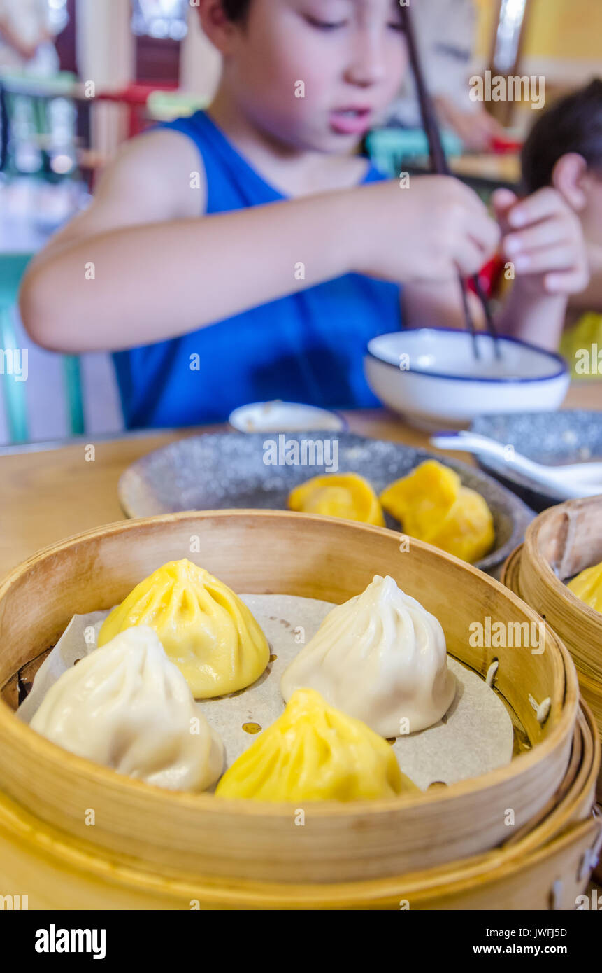 A young boy eats Chinese soup dumplings in Shanghai Stock Photo - Alamy