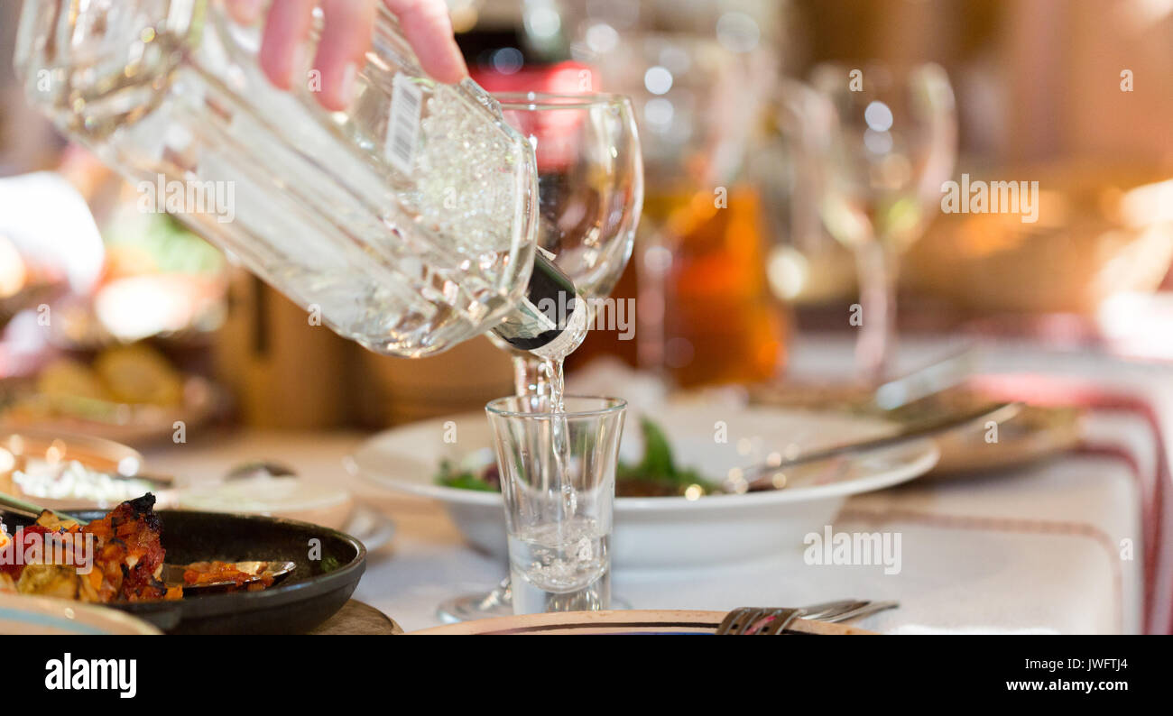 Feast in a restaurant, pouring vodka into the glass closeup Stock Photo ...