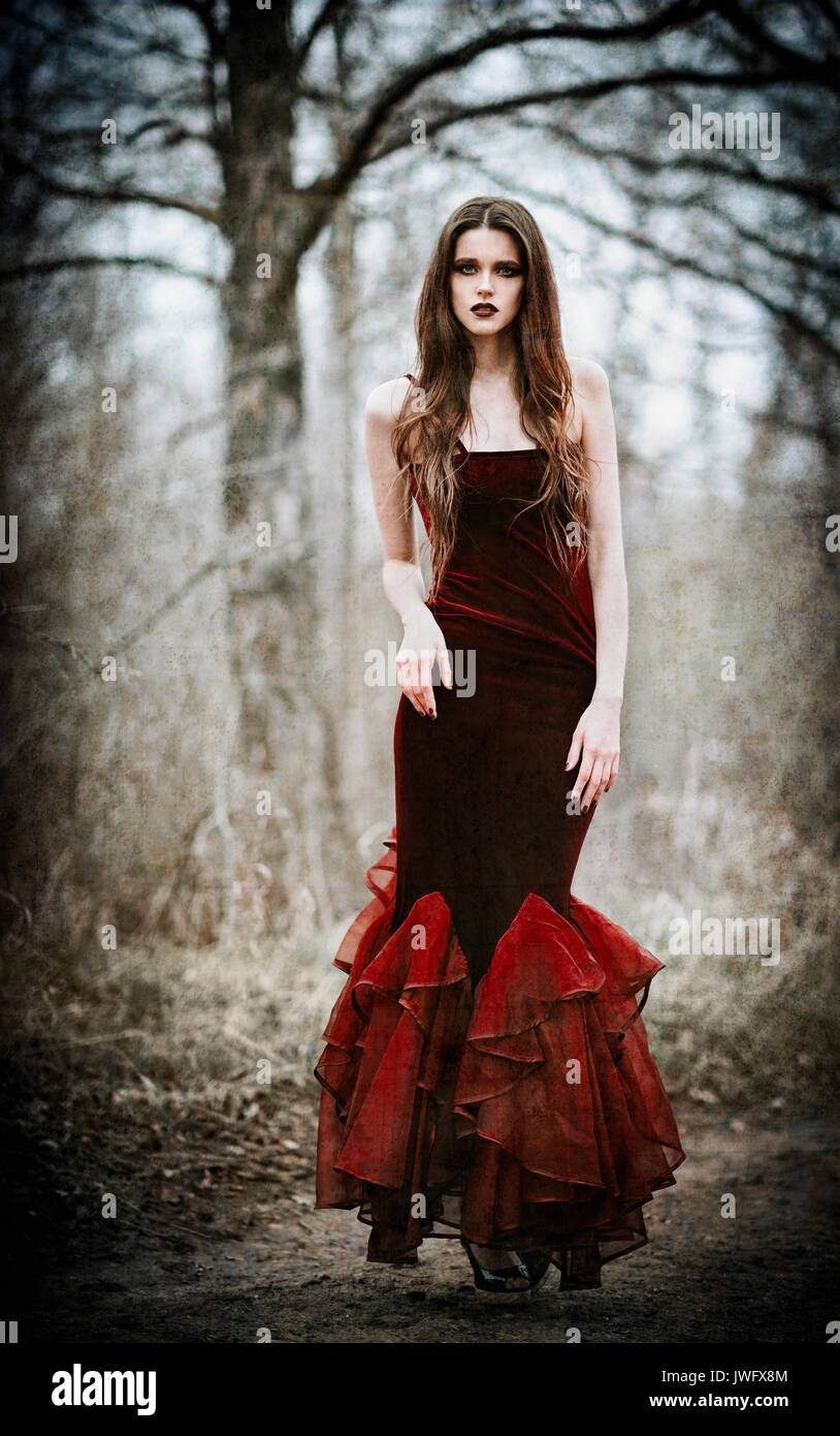 A beautiful sad girl in the autumnal forest. Grunge texture effect ...