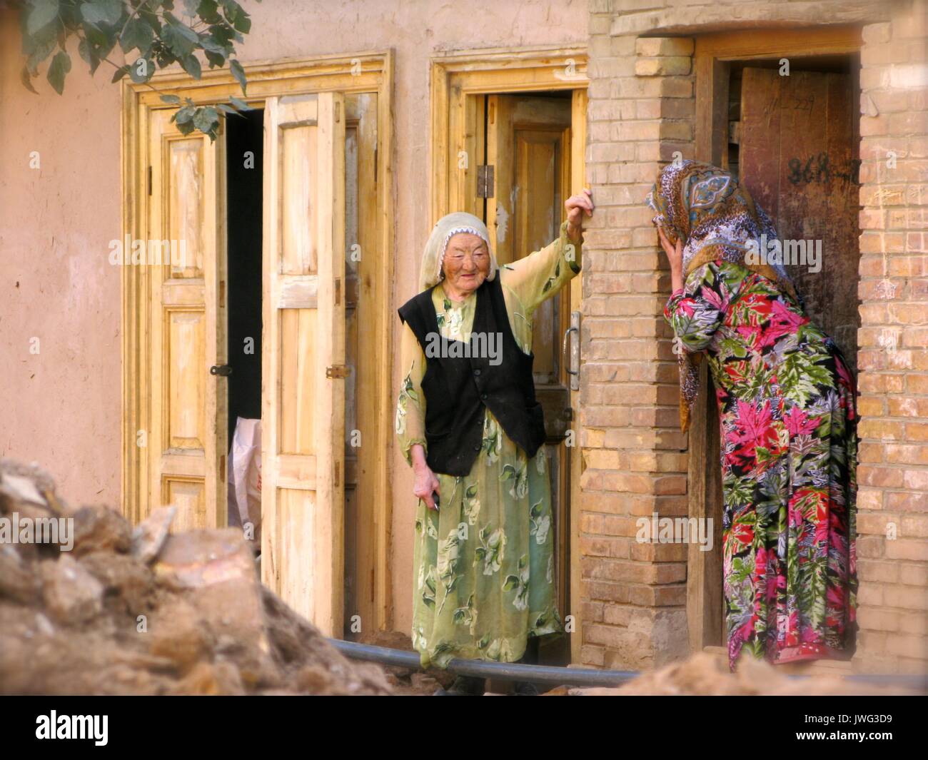 Neighbours gossiping in old town Kashgar Stock Photo - Alamy