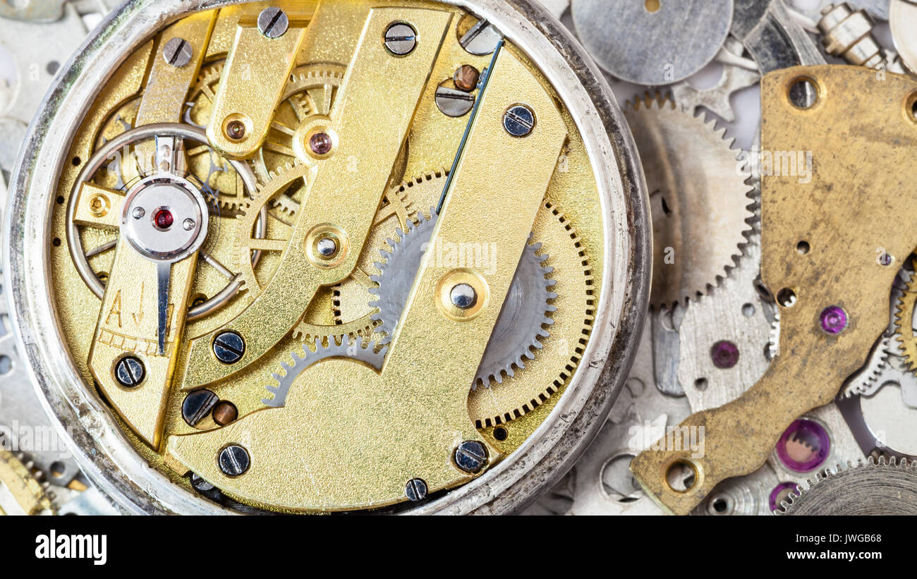 watchmaker workshop - open brass mechanical watch on heap of clock ...