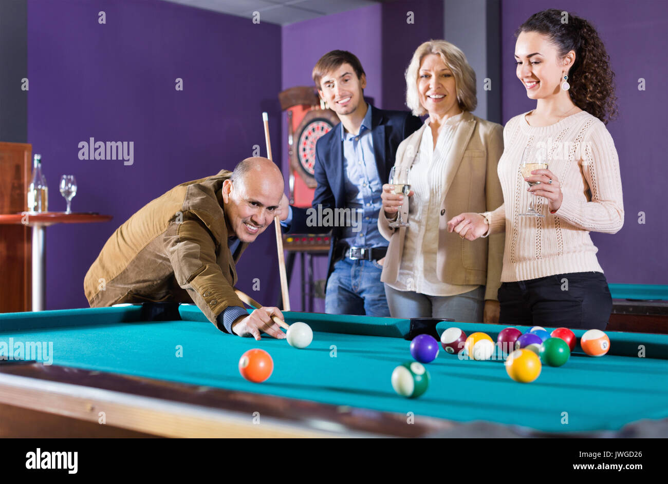 Group of friends playing billiards and smiling in night club Stock ...