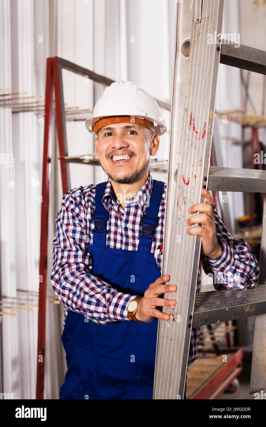 Positive male installer in coverall working at construction site Stock ...
