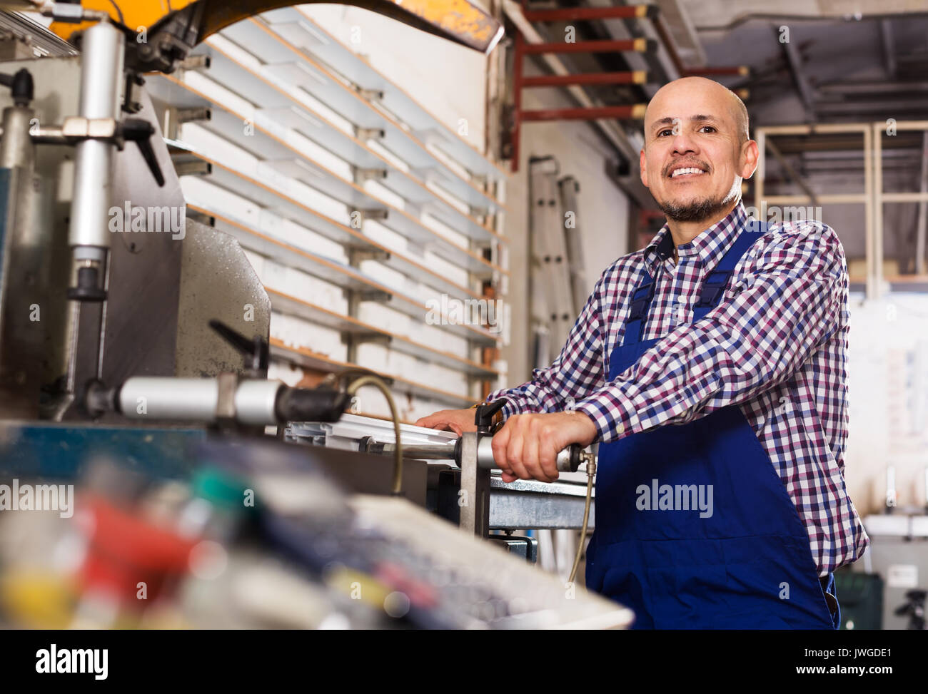 Positive male working on lathe machine at factory Stock Photo - Alamy
