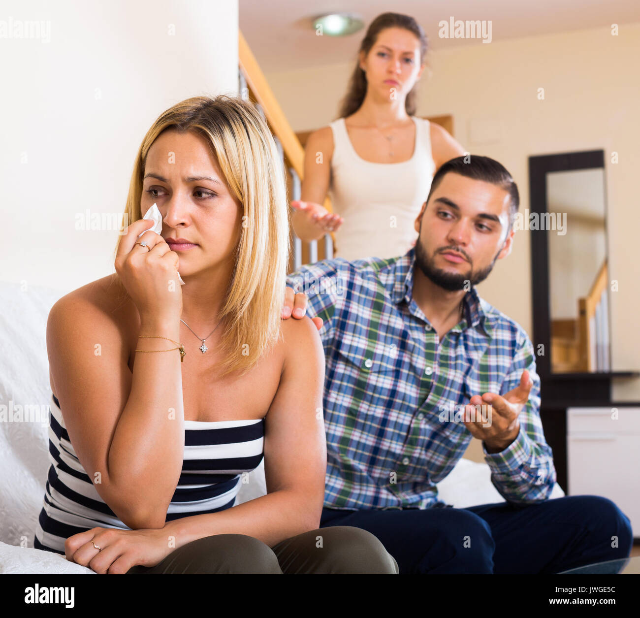 Three stressed young adults having serious conflict at home Stock Photo ...