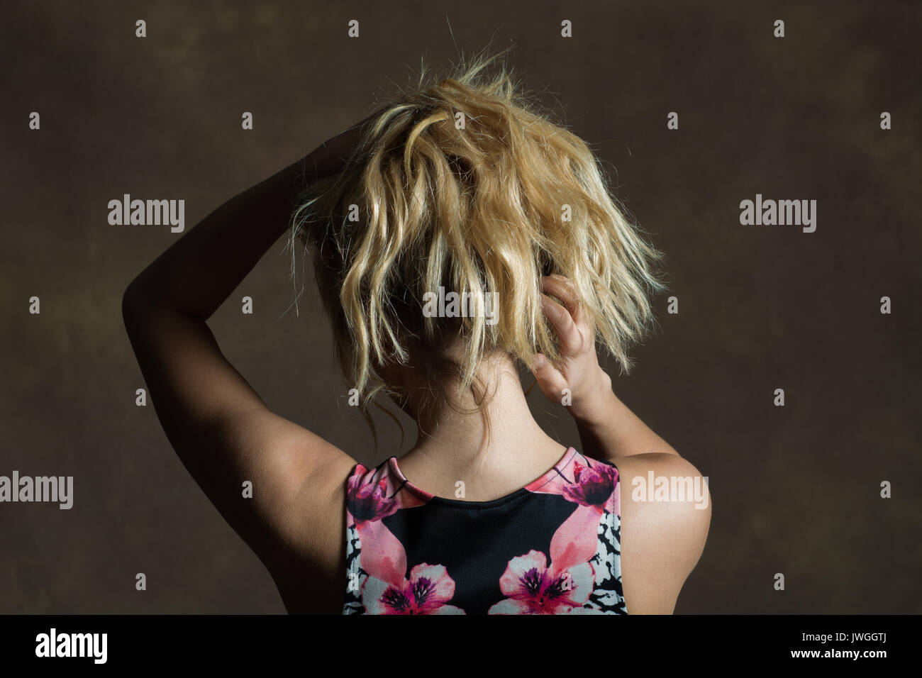 Rear view of a young blond woman hands on hair Stock Photo - Alamy