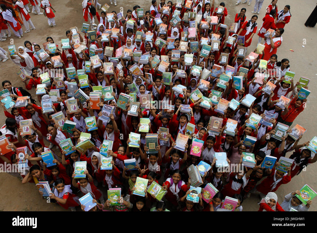 Students from primary and secondary level cheering with new textbooks ...