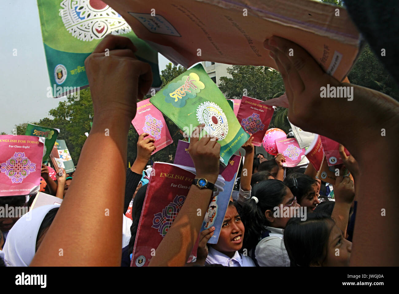 Students from primary and secondary level cheering with new textbooks ...