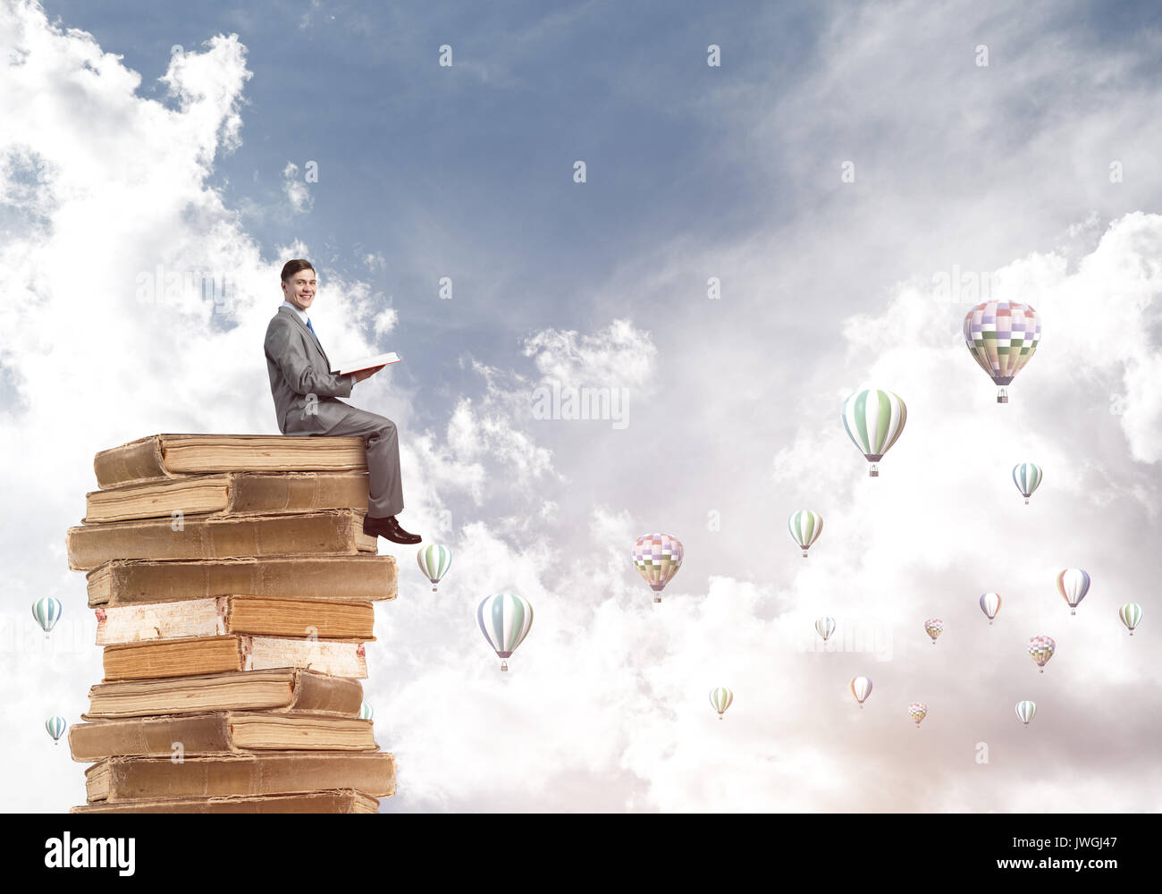 Man student reading book and aerostats flying around in air Stock Photo ...