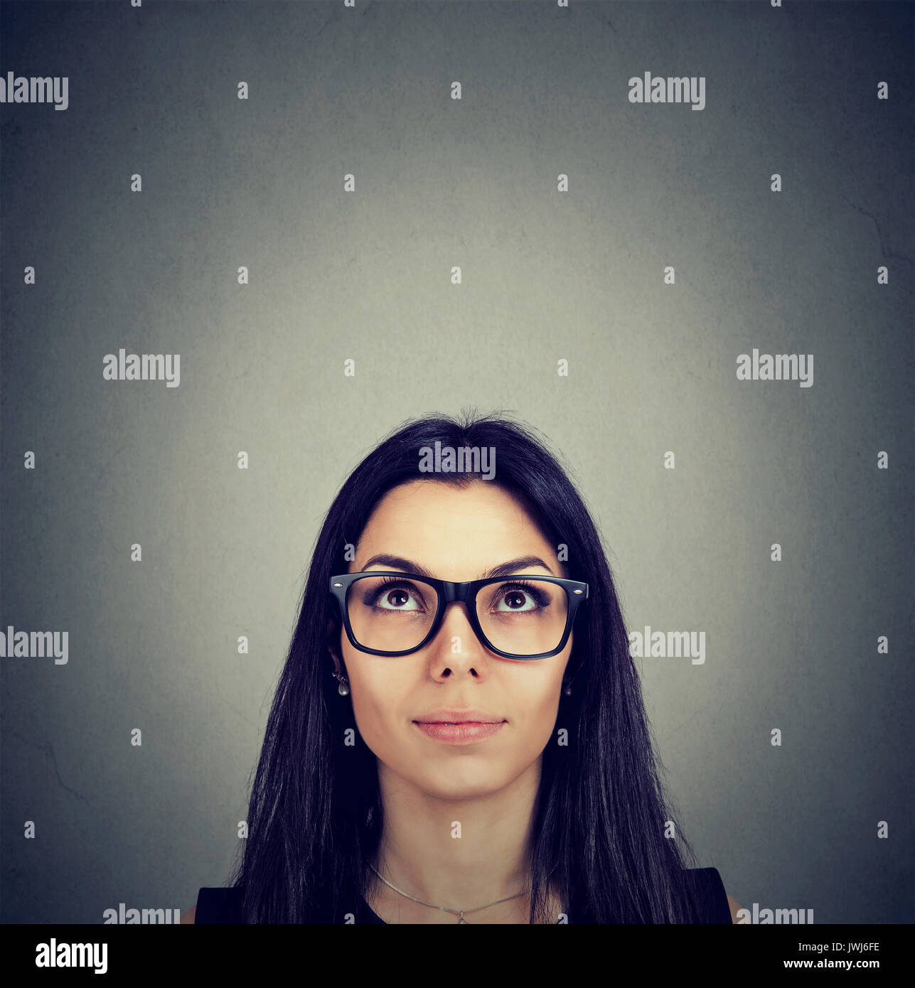 Serious young woman looking up Stock Photo - Alamy