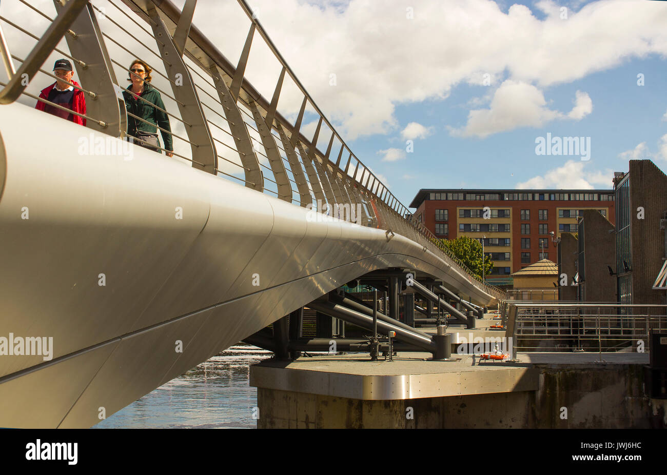 Pedestrians cross the new footbridge across the new flood barrier on ...