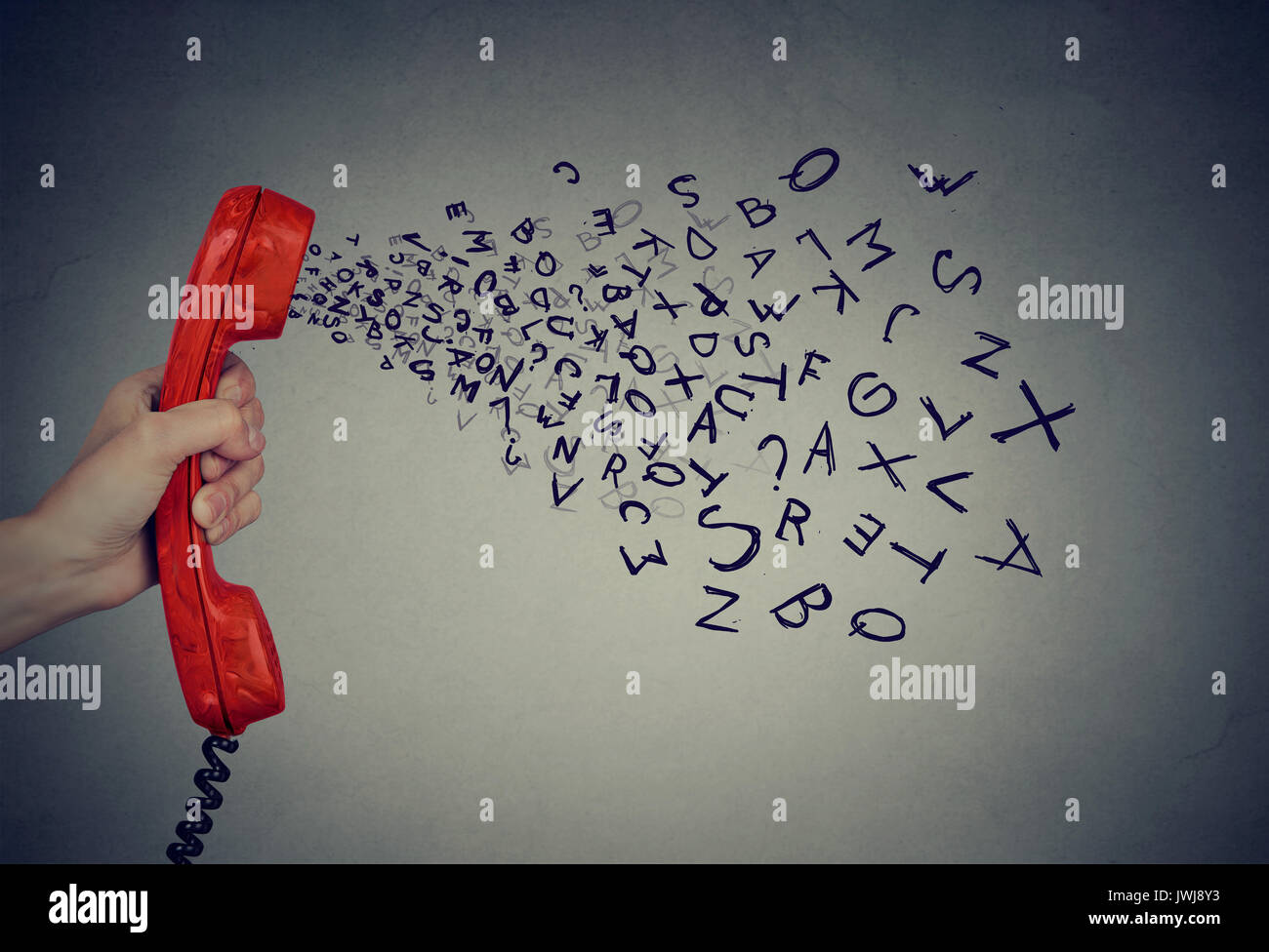Hand holding telephone handset with alphabet letters coming out. Too ...