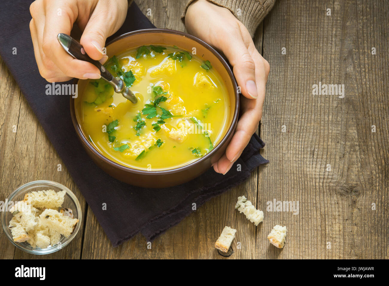 Woman hands holding bowl of vegetable soup with parsley and croutons ...