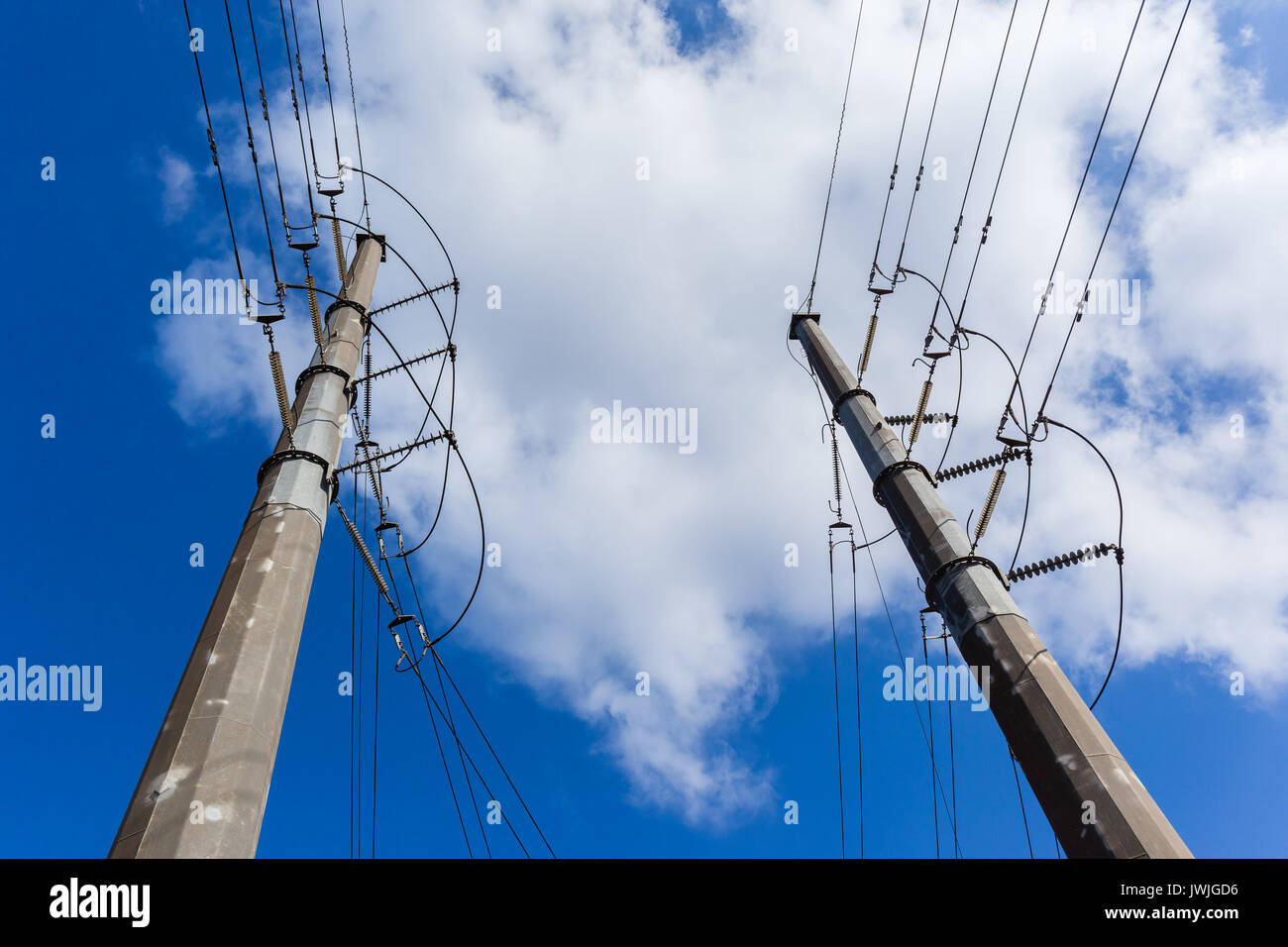Two Steel Towers closeup attached electrical power line cables into ...