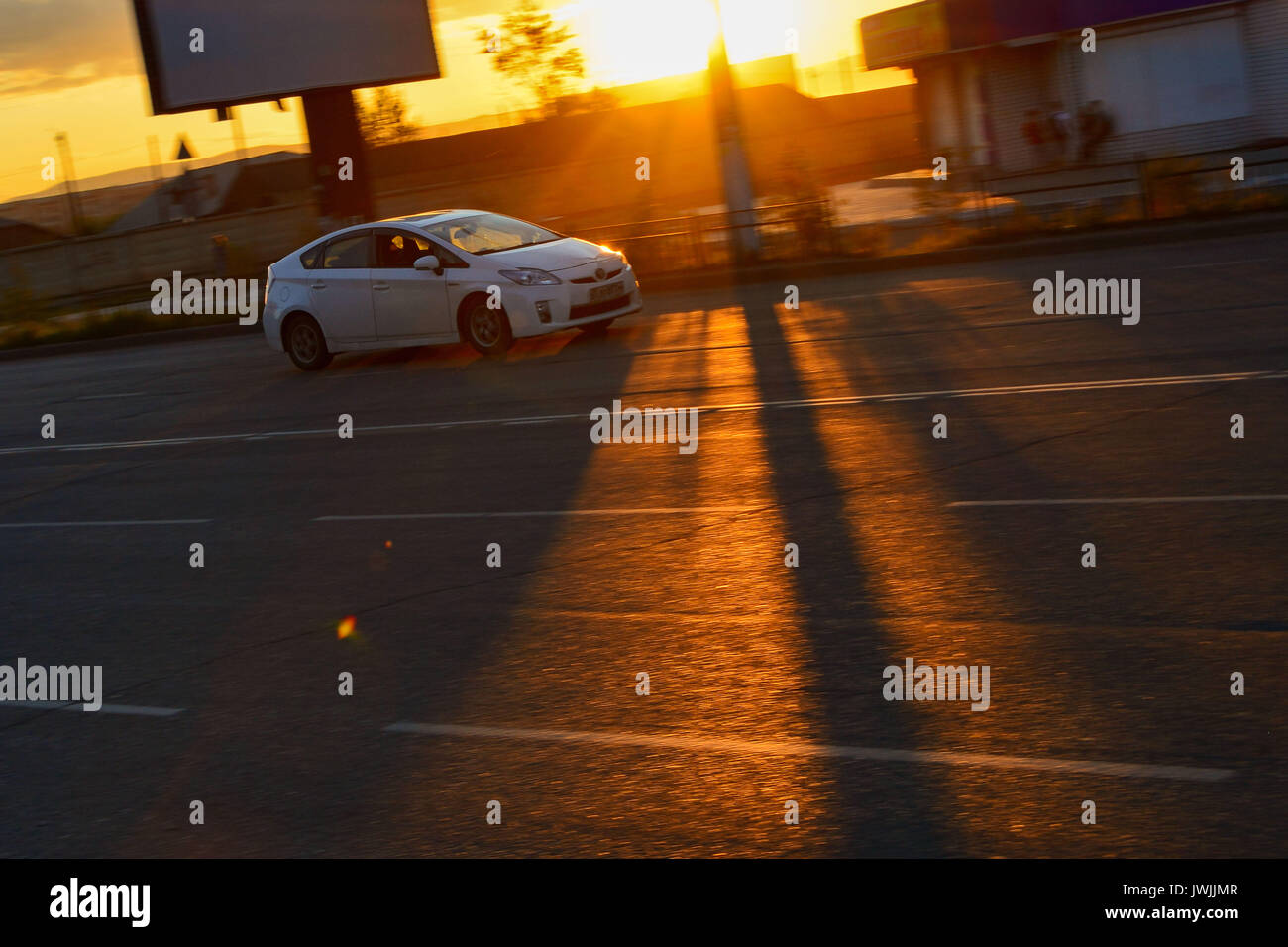 Car driving fast in the city. The sunset with beautiful sun rays in ...