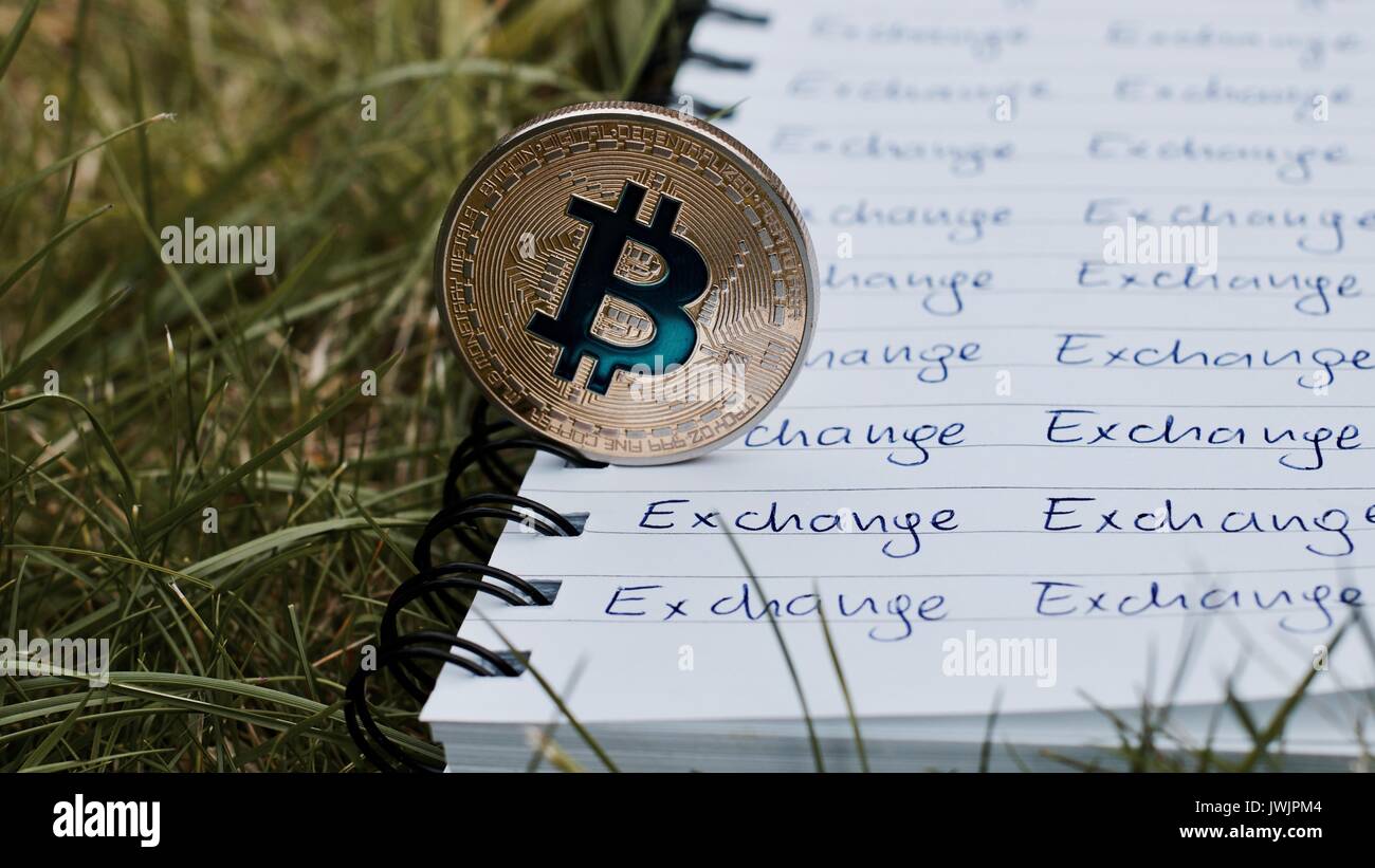 Digital currency physical metal bitcoin coin on the exchange notebook ...