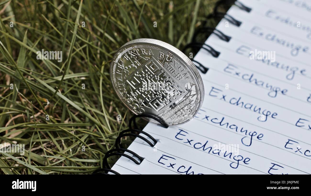 Digital currency physical metal bitcoin coin on the exchange notebook ...