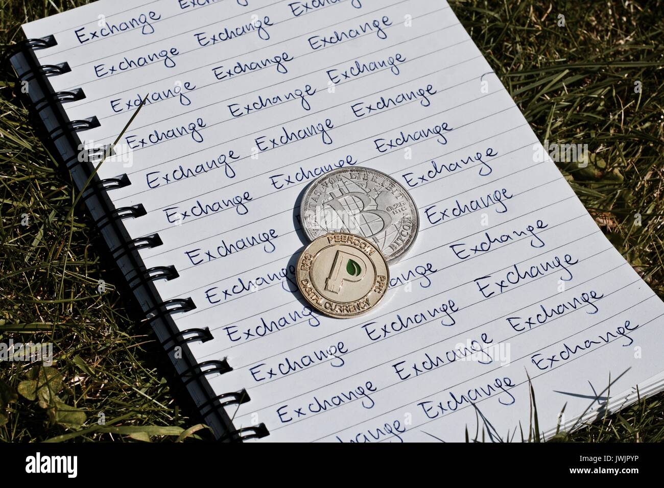 Digital currency physical metal bitcoin coin on the exchange notebook ...