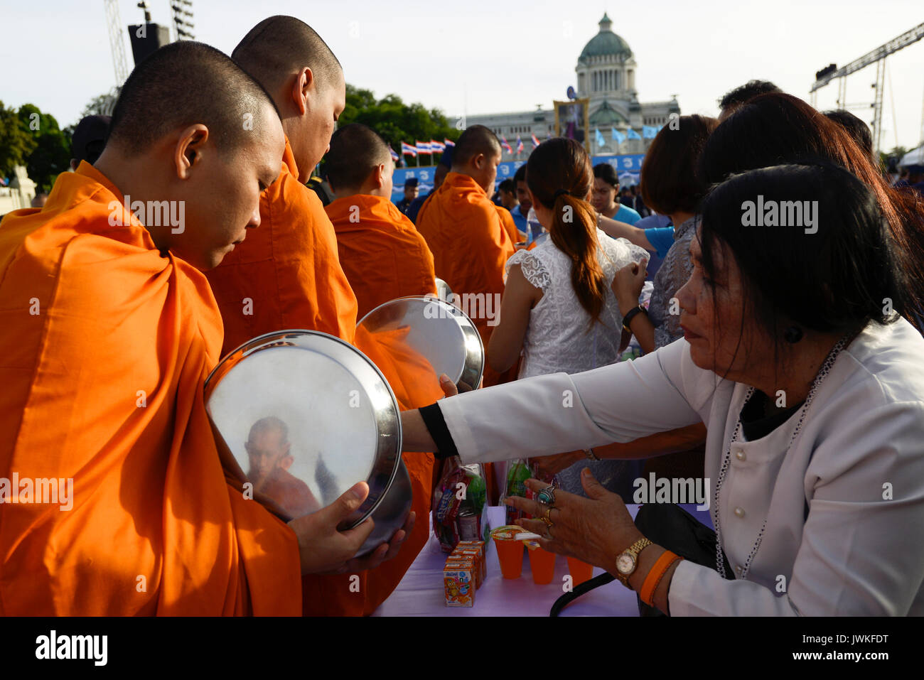 Bangkok, Thailand. 12th Aug, 2017. Thai Buddhist devotees give alms to ...