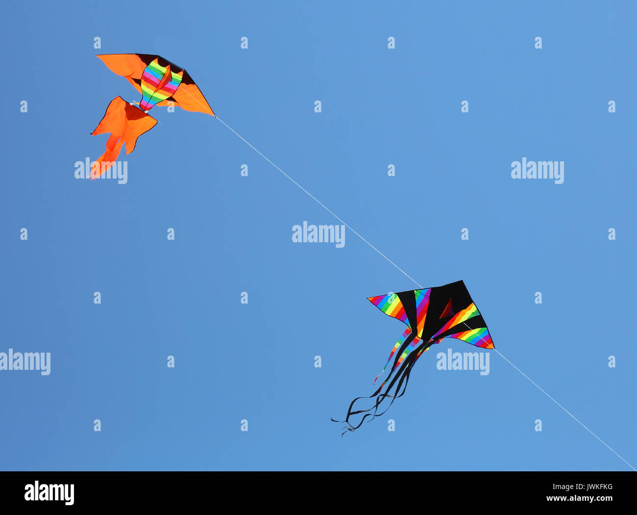 Two big kites fly high in the blue sky Stock Photo - Alamy