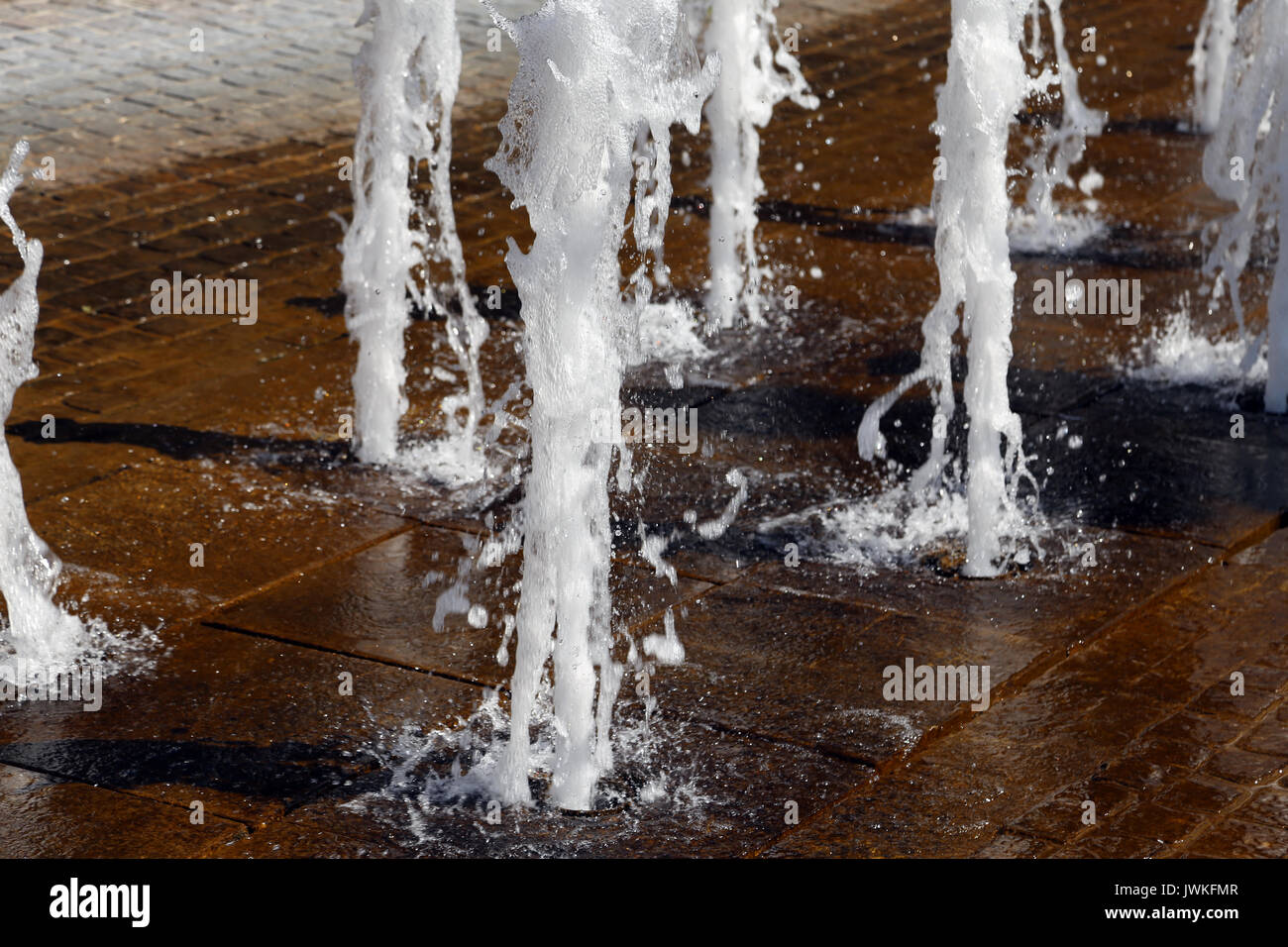 White sparkling fountain splashes in summer in a city Stock Photo - Alamy