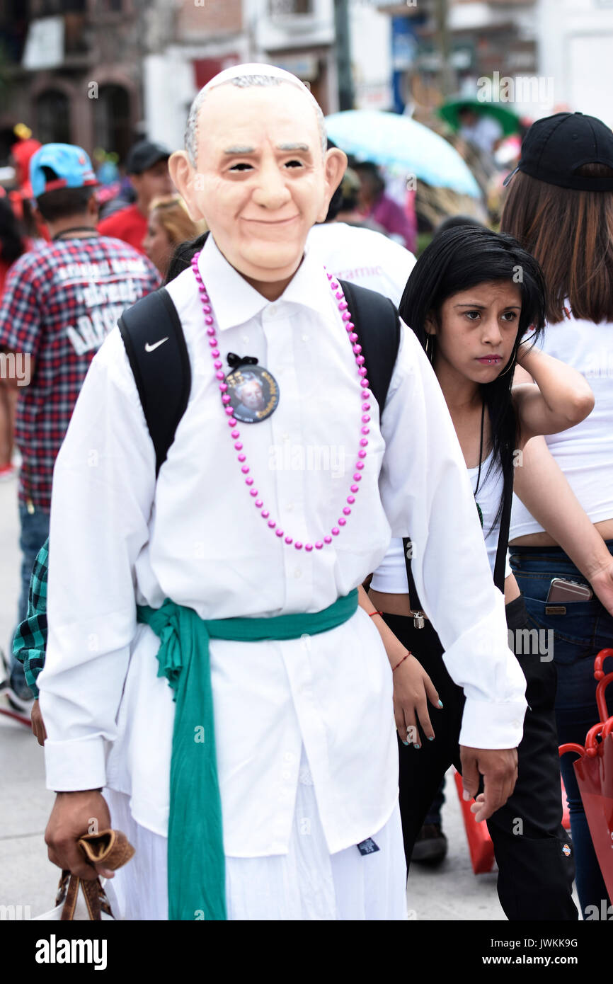 A participant dressed in Pope costume pose for a picture as he walks ...