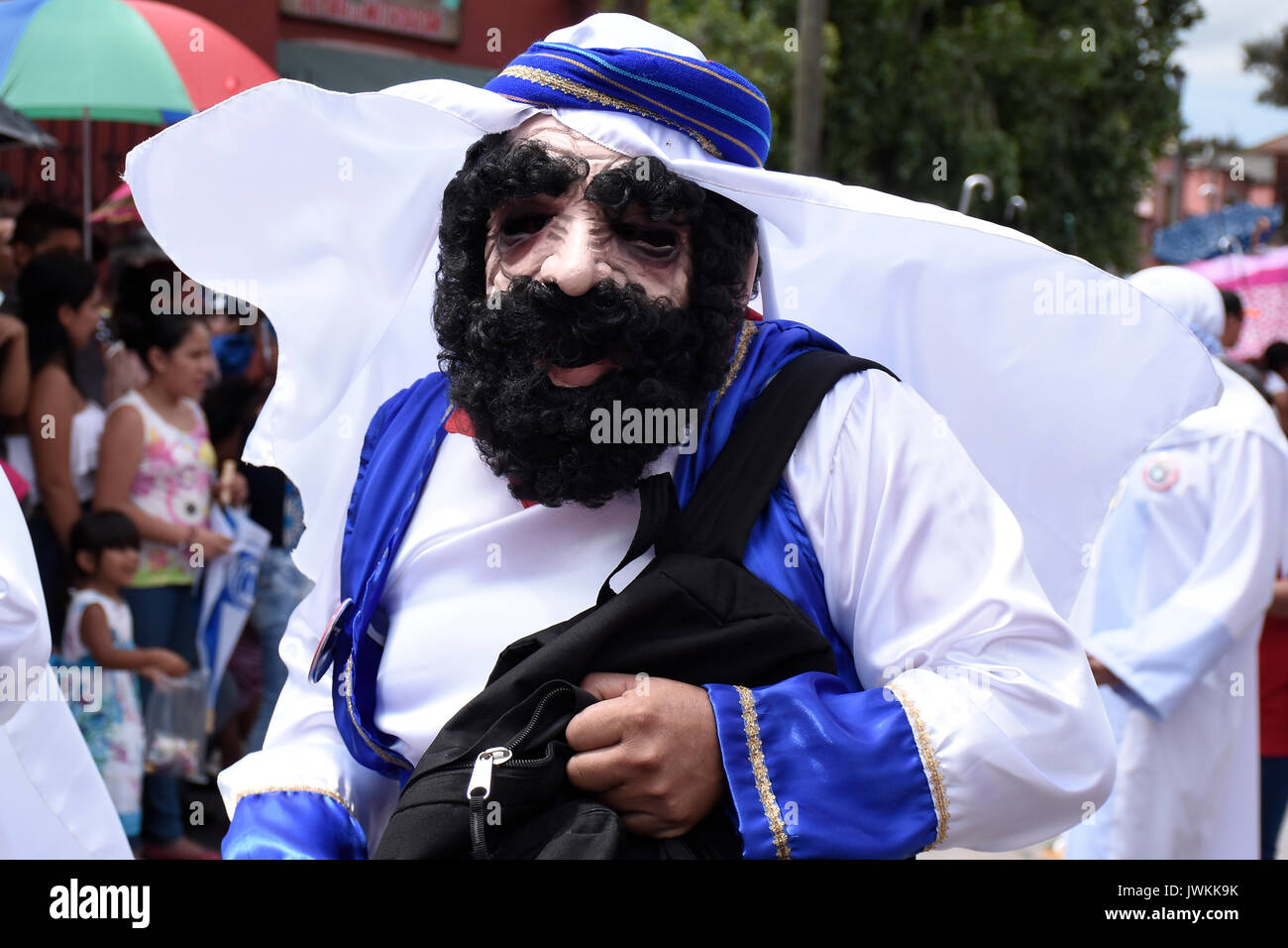 A participant dressed in bizarre costume pose for a picture as he walks ...