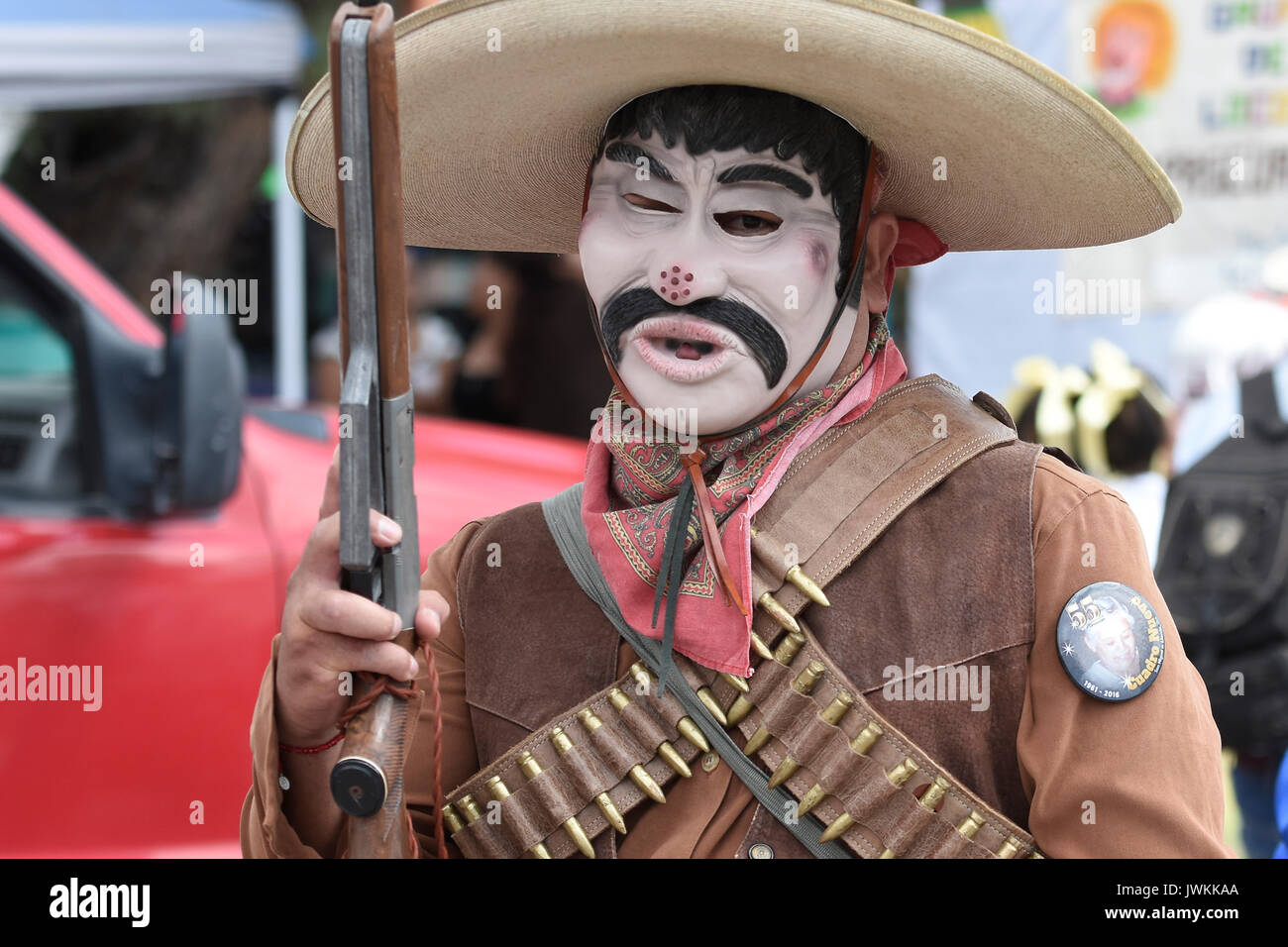 A participant dressed in bizarre costume pose for a picture as he walks ...