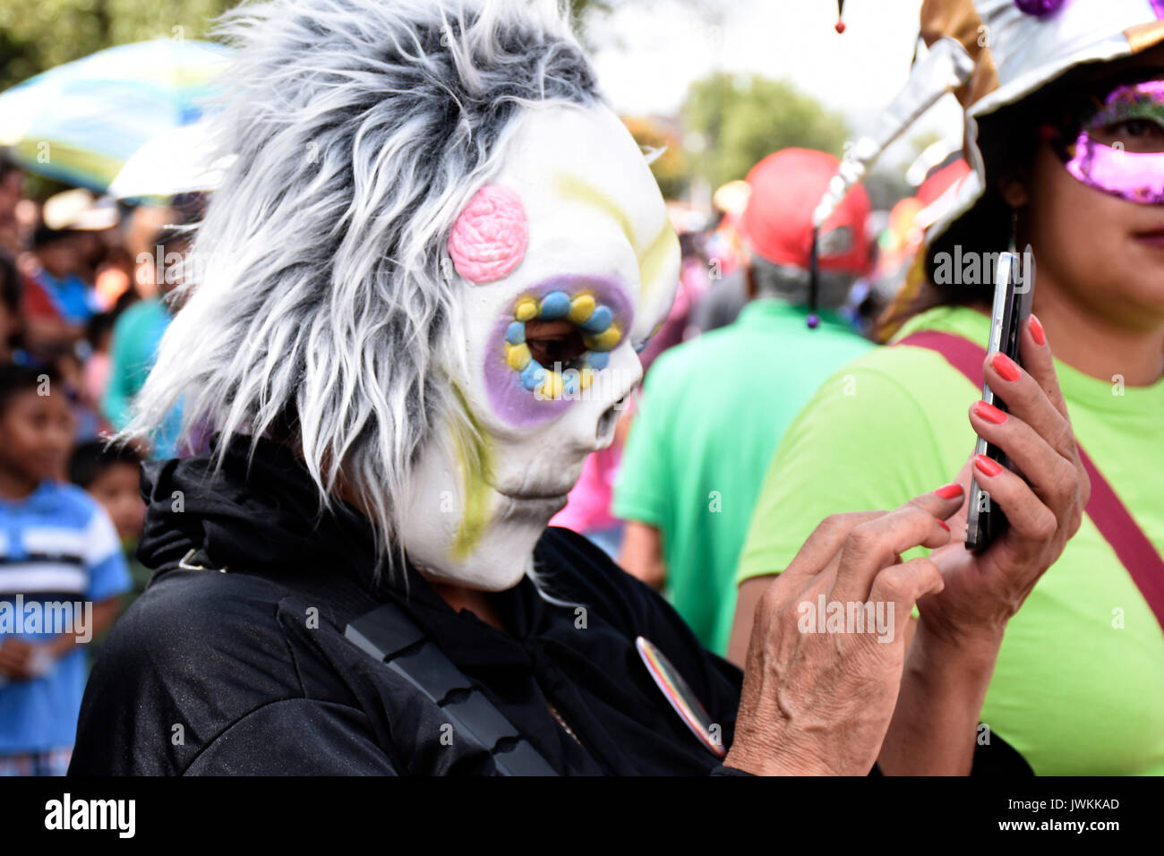 A participant dressed in bizarre costume takes a picture with his ...