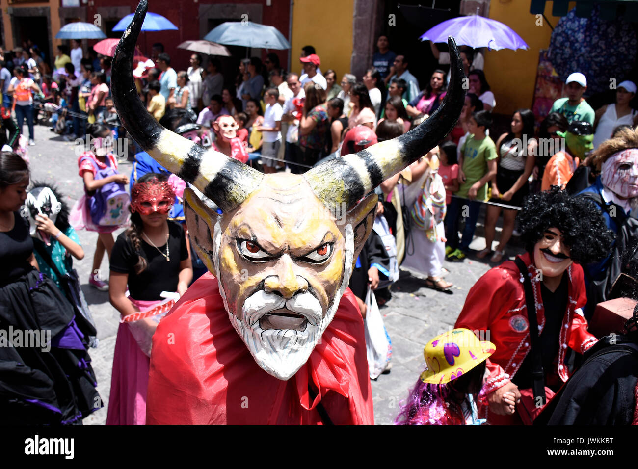 Participants dressed in colourful bizarre costume are walking though ...