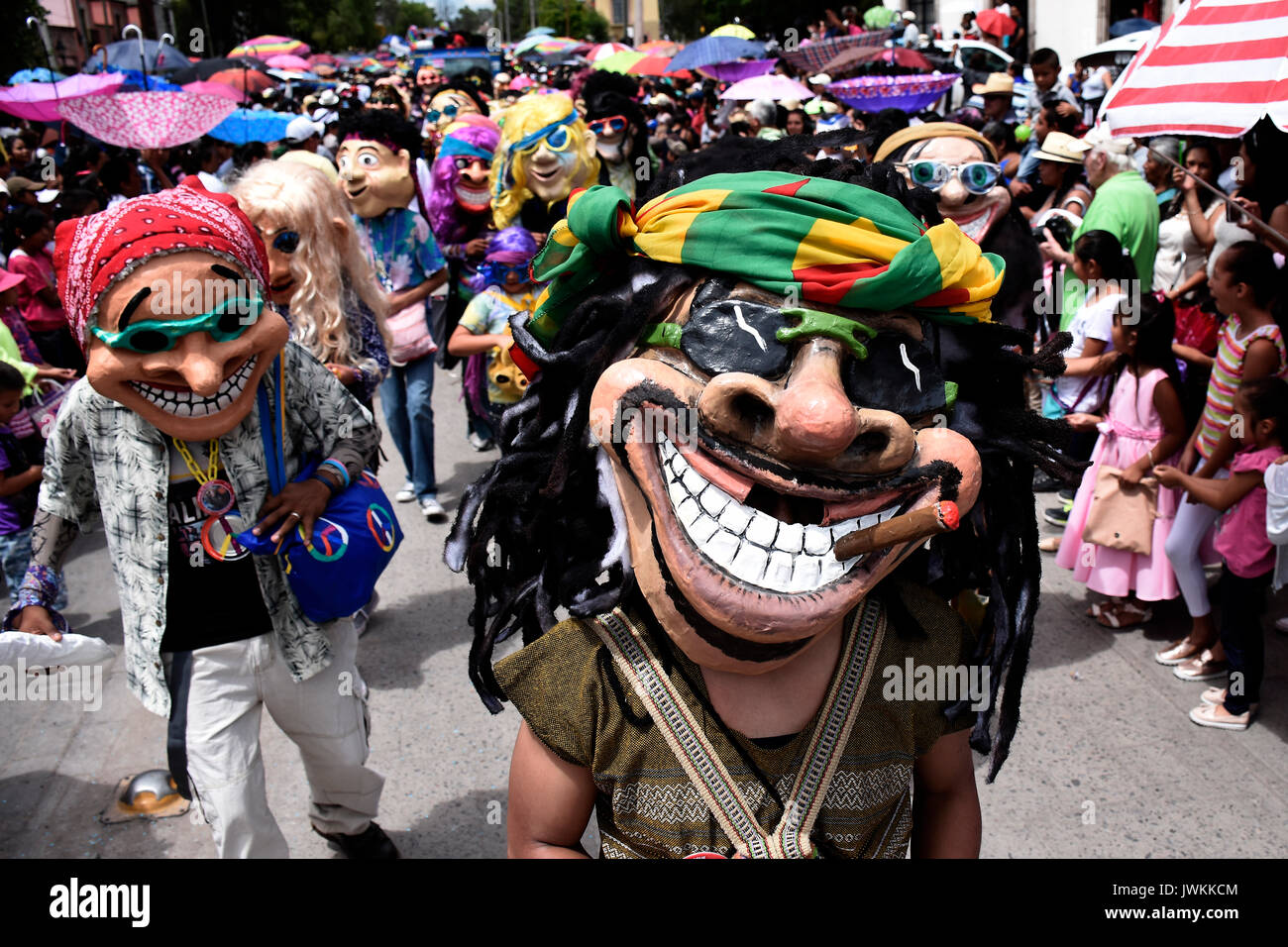 Participants dressed in colourful bizarre costume are walking though ...