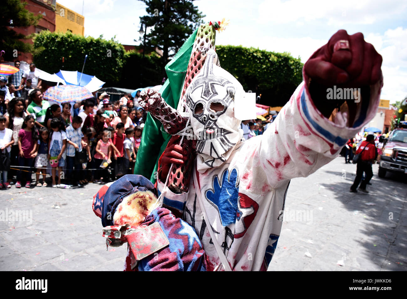 A participant dressed in colourful bizarre costume pose for a picture ...