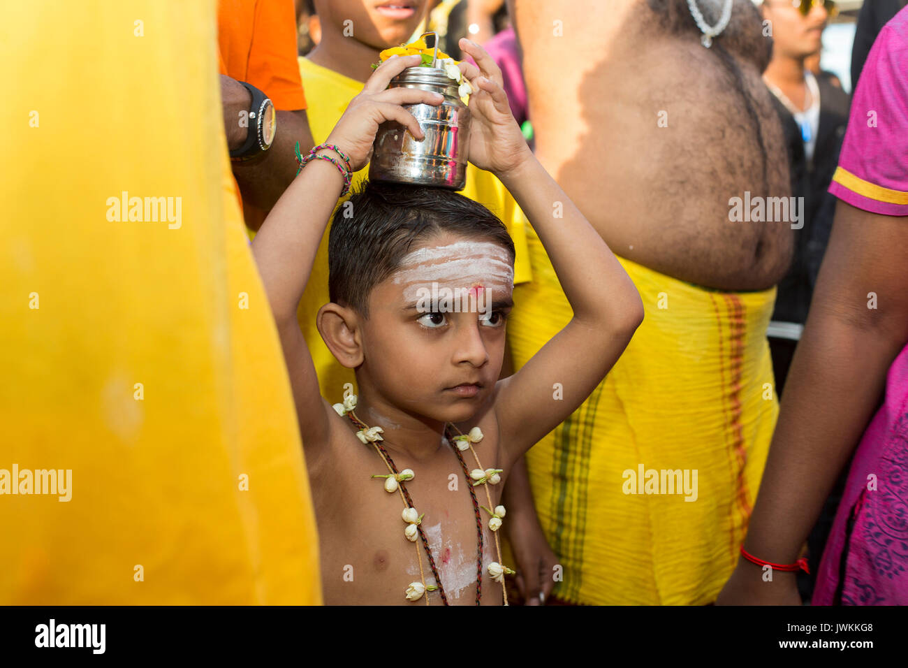 A Hindu child carries a bowl of milk as an offering during the ...