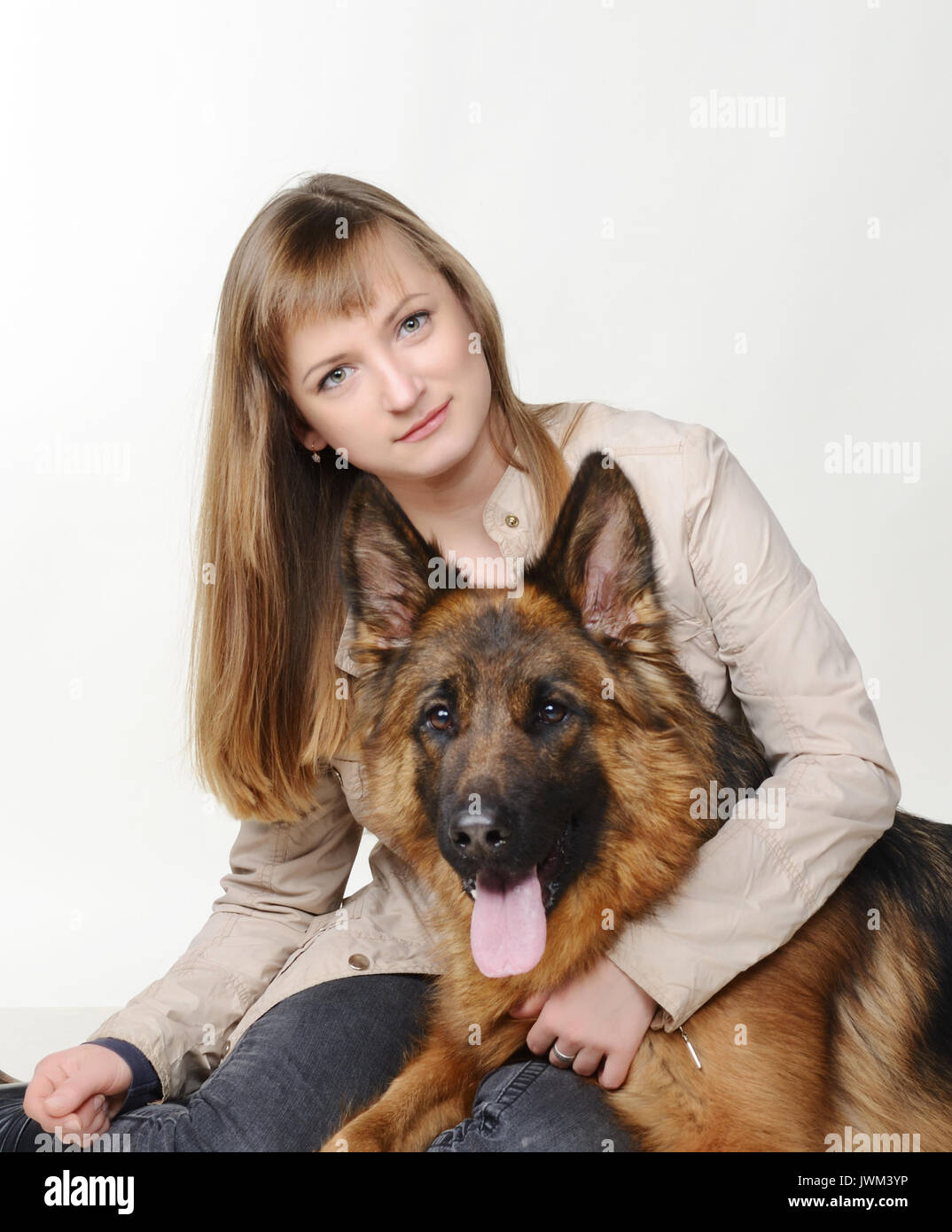 Young Woman hugs beautiful fluffy German Shepherd dog against white ...