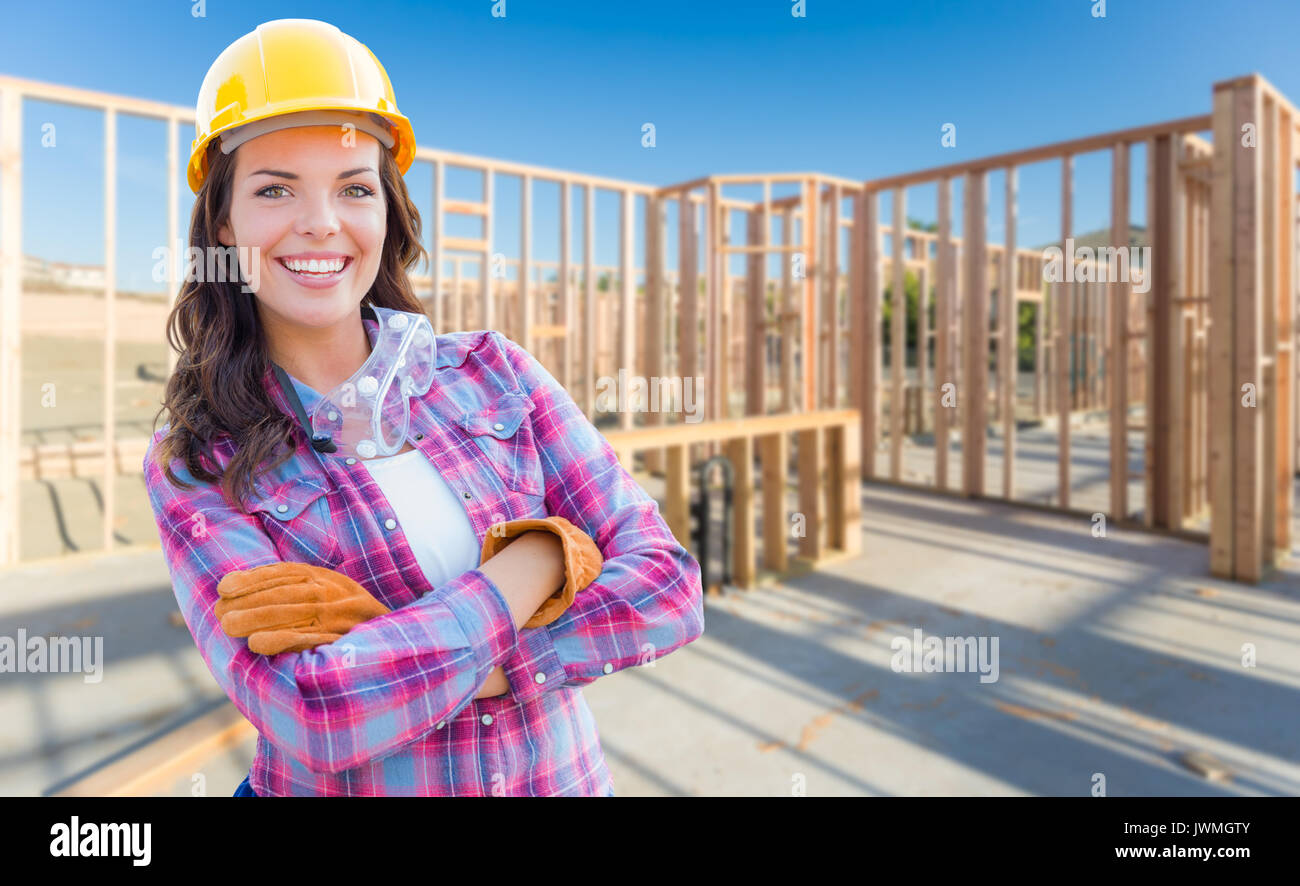 Young Attractive Female Construction Worker Wearing Gloves, Hard Hat and Protective Goggles At ...