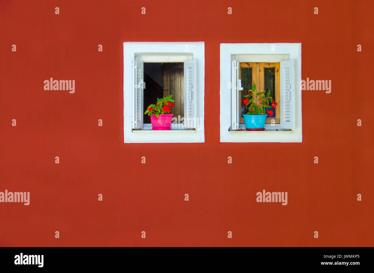 Colorful red facade with two windows Stock Photo - Alamy