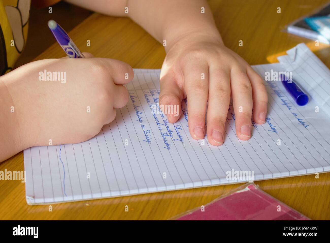 Hands of a school child writing their homework or studying the ...