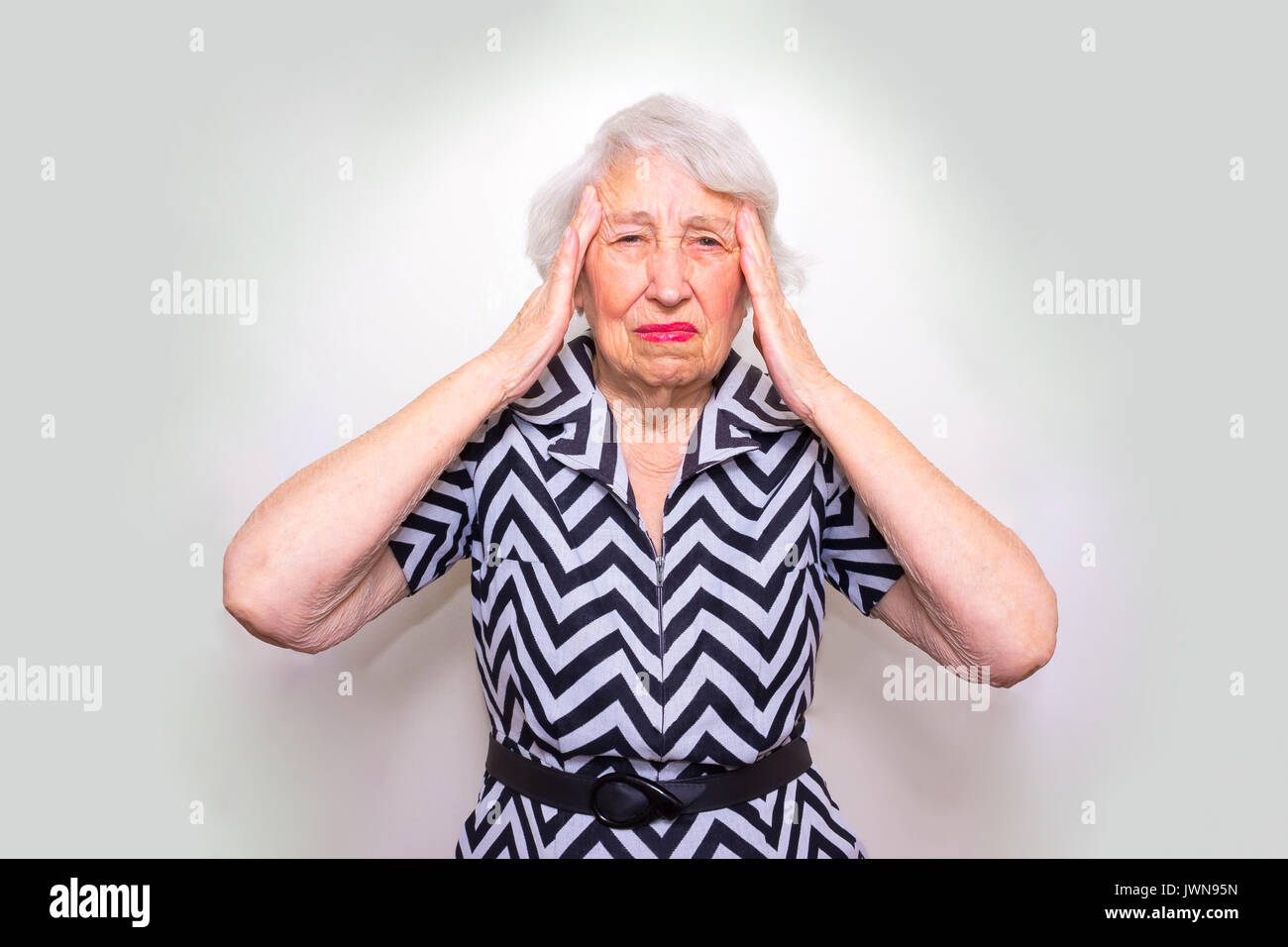 Senior Woman With Head In Hands Looking Weary Stock Photo - Alamy